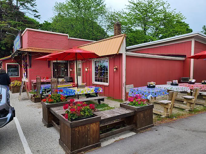 The cherry-red exterior of Scaturo's welcomes visitors like a warm hug, complete with colorful picnic tables and flower boxes that scream "Sit! Eat! Stay awhile!"