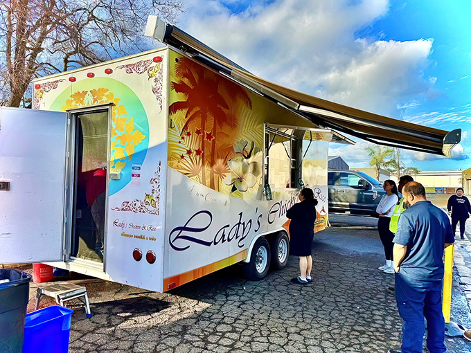The humble white food truck with vibrant orange accents stands like a beacon of flavor under Central Valley sunshine, complete with shaded seating for those who can't wait to dig in.
