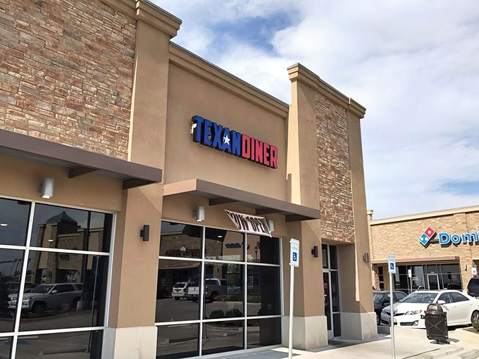 The iconic blue and red Texan Diner sign beckons from its stone facade like a patriotic beacon for hungry travelers.