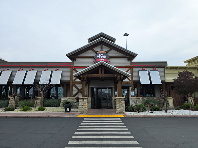 The 49er Diner's rustic exterior welcomes hungry travelers like a gold rush promise &ndash; comfort food treasures await just beyond those wooden beams and stone pillars.