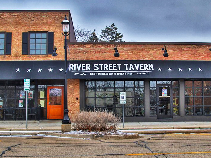 The brick facade of River Street Tavern beckons like an old friend, that distinctive orange door promising comfort and culinary adventures within.