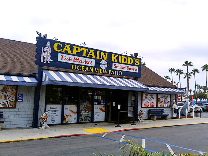 The blue-and-white striped awning of Captain Kidd's stands like a maritime beacon, promising seafood treasures within. Palm trees sway in agreement.