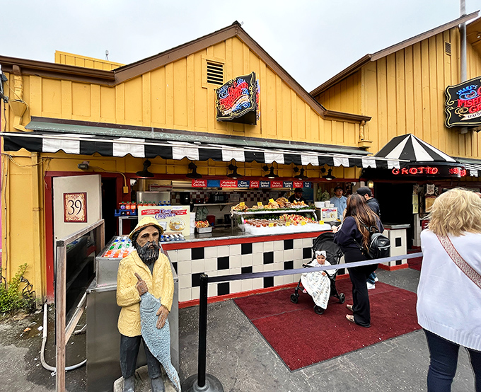 The cheerful yellow exterior of Old Fisherman's Grotto stands like a beacon of culinary promise, complete with a whimsical fisherman statue greeting hungry visitors.