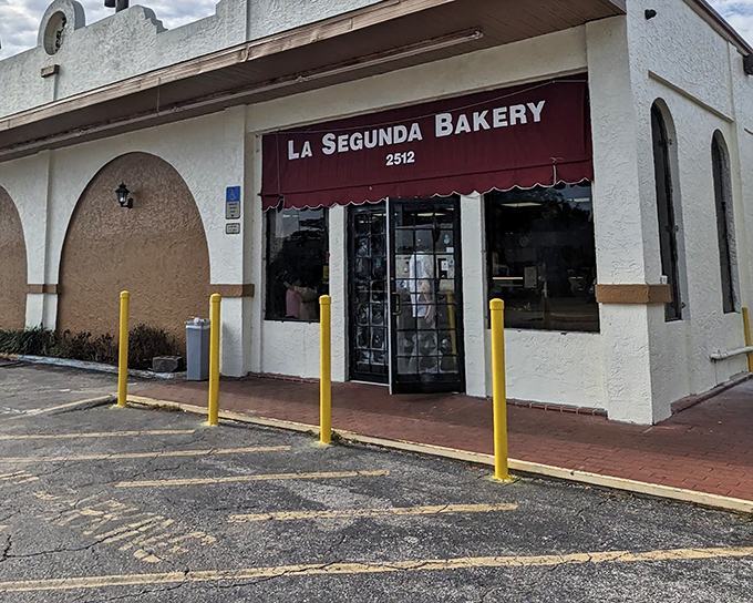 The unassuming storefront with its burgundy awning hides a century of culinary history. Like finding a secret passage to Cuban bread paradise.
