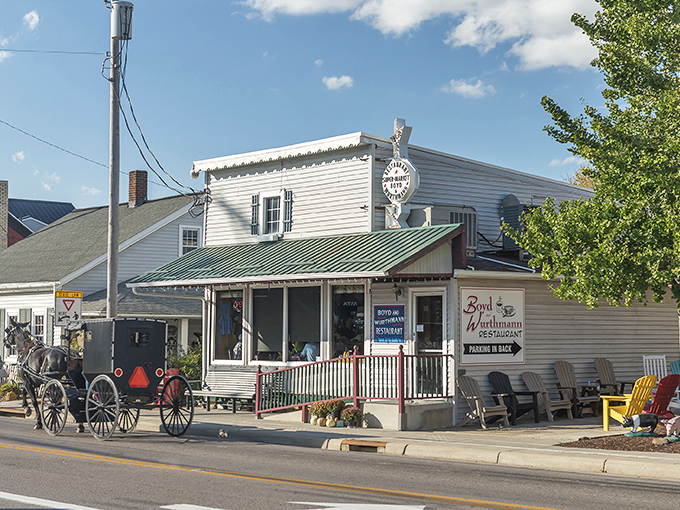 Where horse-drawn buggies meet hungry travelers, this unassuming white clapboard building houses fried chicken that would make your grandmother jealous.