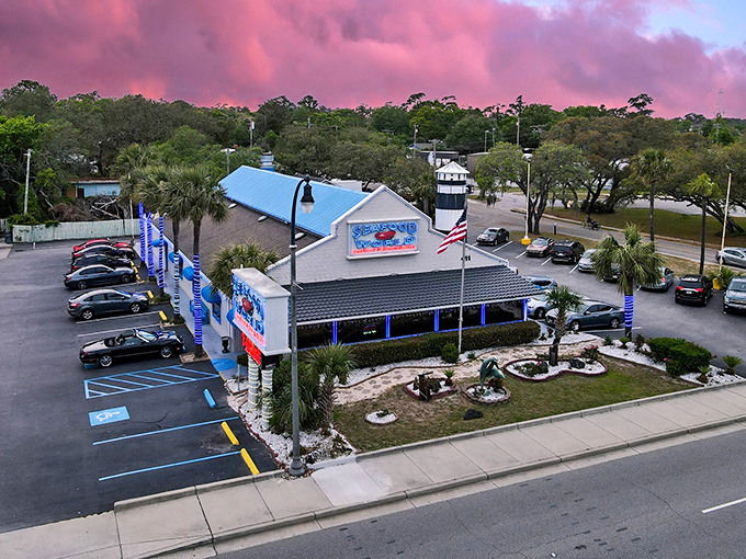 The classic coastal charm of Seafood World beckons under Carolina blue skies, where that American flag promises patriotic portions of seafood treasures.