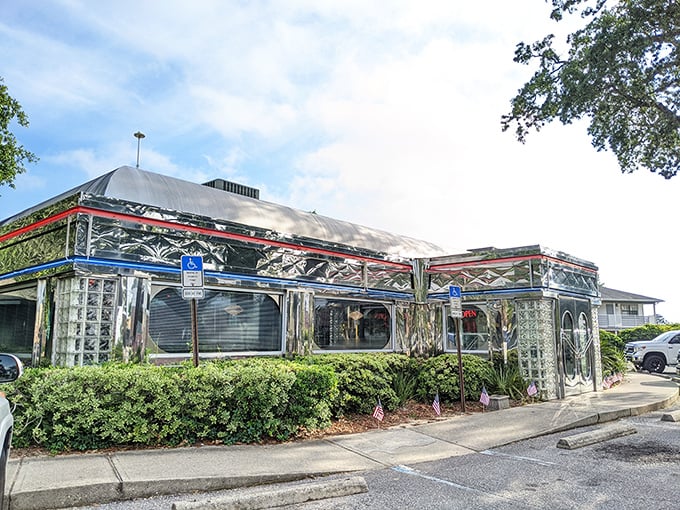 The chrome-clad exterior of Scenic 90 Cafe glows at dusk, a shining beacon of comfort food that promises nostalgic flavors inside those glass brick walls.