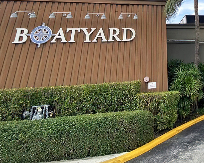 The nautical-inspired exterior of Boatyard welcomes seafood lovers with its compass logo and meticulously maintained hedges&mdash;Florida dining with maritime flair.
