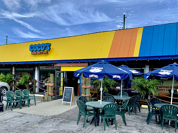 The sunshine-yellow exterior of Coco's isn't just a building—it's a mood announcement. Florida casual meets Maryland seafood tradition under those blue Surfpind umbrellas.