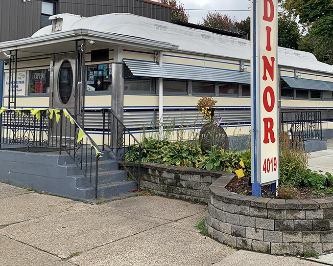 The classic "DINOR" sign beckons like a neon lighthouse, promising comfort food and conversations in this vintage Erie treasure.