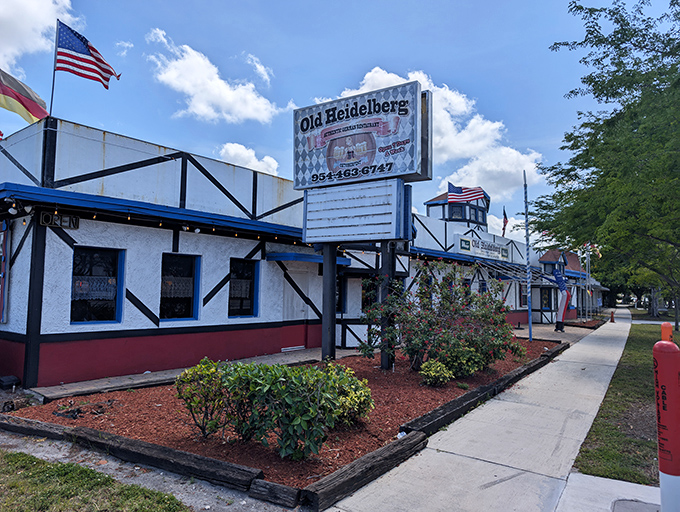 Bavaria meets Florida at Old Heidelberg's distinctive Tudor-style exterior. German flags flutter alongside the Stars and Stripes, promising authentic European flavors in Fort Lauderdale.