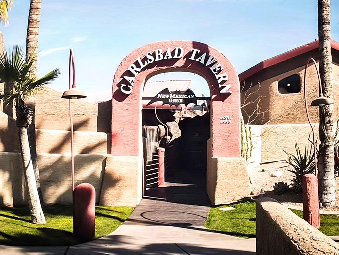 The pink adobe archway beckons like a portal to flavor country. Desert landscaping and palm trees hint at the Southwestern adventure awaiting inside.