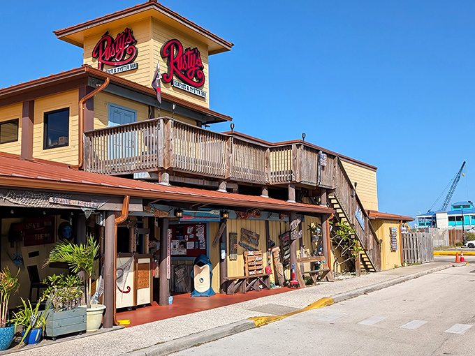 Rusty's sunny yellow exterior stands like a beacon for seafood lovers, with its weathered wooden deck promising waterfront views and maritime memories.