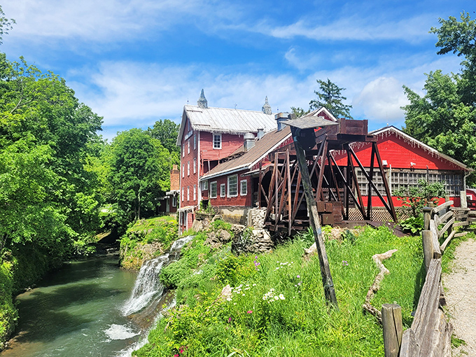 The iconic red mill perched above cascading waterfalls creates a scene so perfect you'll wonder if you've stumbled onto a movie set.