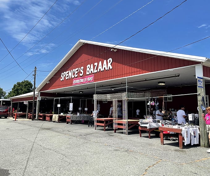 The iconic red barn of Spence's Bazaar stands like a treasure chest waiting to be opened, with vendors already setting up their wares outside.