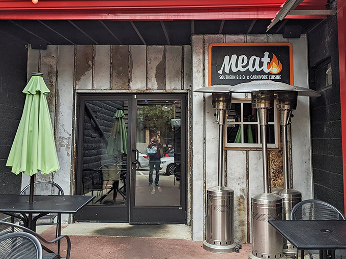 The entrance to Meat BBQ beckons like a smoky siren call, with rustic charm and that red sign promising delicious things ahead.