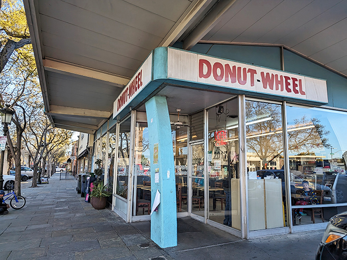 The iconic blue-pillared facade of Donut Wheel stands as a beacon of sweetness on Livermore's First Street, promising 24-hour donut salvation.