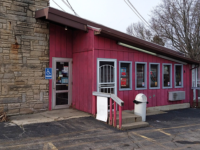The unassuming red exterior of Porky's Drive-In stands like a time capsule on Ashland Road, promising honest food without pretense since 1949. 