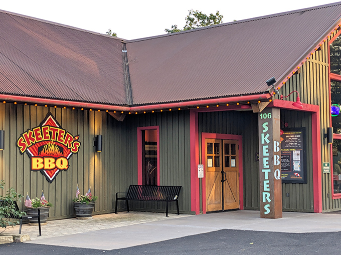 The green cabin-like exterior of Skeeter's BBQ stands like a rustic temple to smoked meat, its red-trimmed windows promising delicious secrets within.
