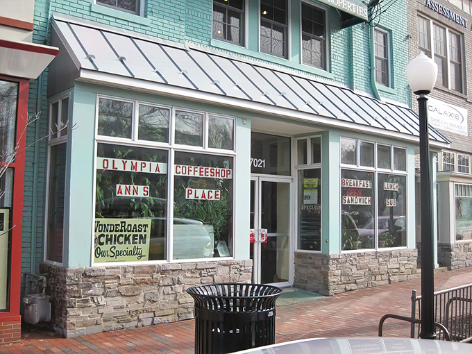 The mint-green facade of Olympia Cafe stands like a time capsule on Chevy Chase's brick-lined street, promising comfort food treasures within.