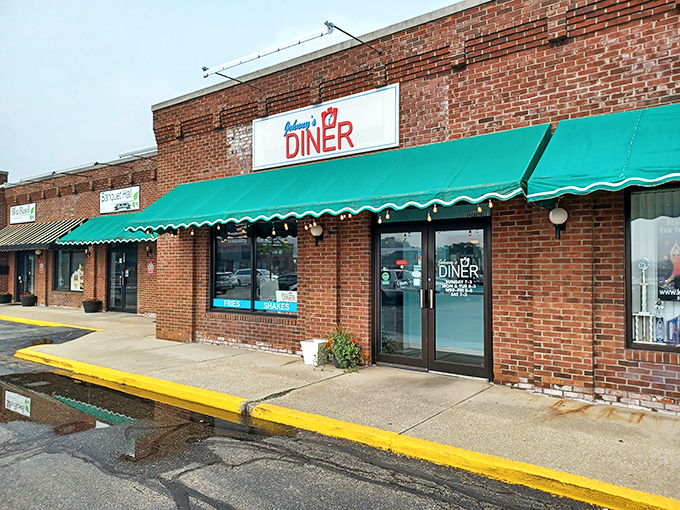 The unassuming brick exterior of Johnny's Diner, with its cheerful green awning, promises nostalgic comfort like a warm hug from your favorite aunt.