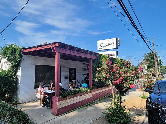 The unassuming exterior of Scrambled, where vines embrace the building like they're trying to keep all the deliciousness from escaping into the wild.