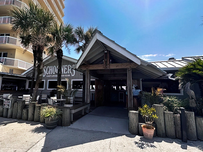 The ultimate beach bum's paradise! Schooners proudly declares itself the "Last Local Beach Club," with motorcycles parked out front like exclamation points to that statement.