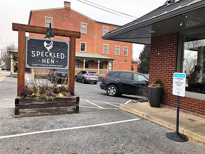 The unassuming brick exterior of Speckled Hen hides culinary treasures within. That wooden sign promises craft coffee and artisan food&mdash;spoiler alert: it delivers both spectacularly.