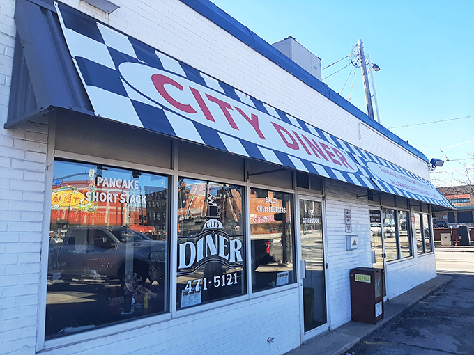 The checkered awning beckons like a black-and-white flag signaling "good food ahead." City Diner's unassuming exterior promises authentic diner magic within.