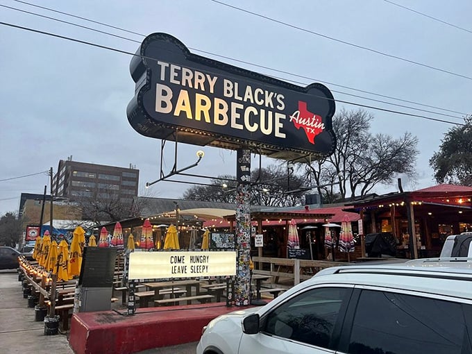 The neon BBQ sign glows like a smoky beacon of hope for hungry travelers. Terry Black's industrial-chic exterior promises no frills&mdash;just exceptional barbecue worth the journey.