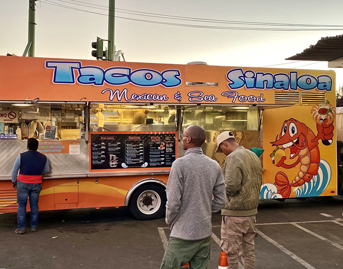 The vibrant orange truck with its cartoon shrimp mascot stands like a beacon of taco hope on International Boulevard. Street food paradise found!