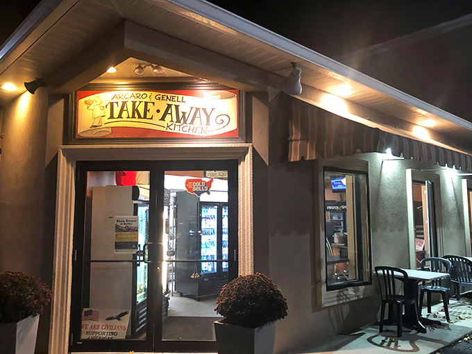 The glowing "TAKE-AWAY KITCHEN" sign at Arcaro and Genell beckons like a lighthouse for hungry travelers in Old Forge's pizza paradise.