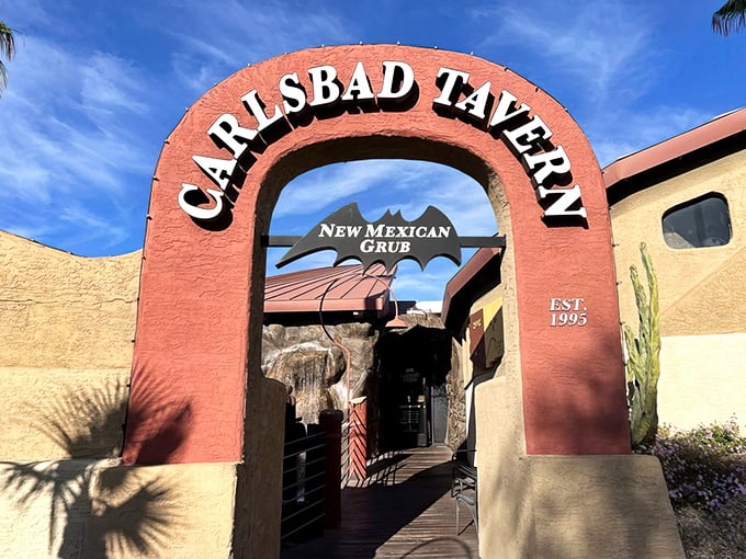 The pink adobe archway beckons like a portal to flavor country. Desert landscaping and palm trees hint at the Southwestern adventure awaiting inside.
