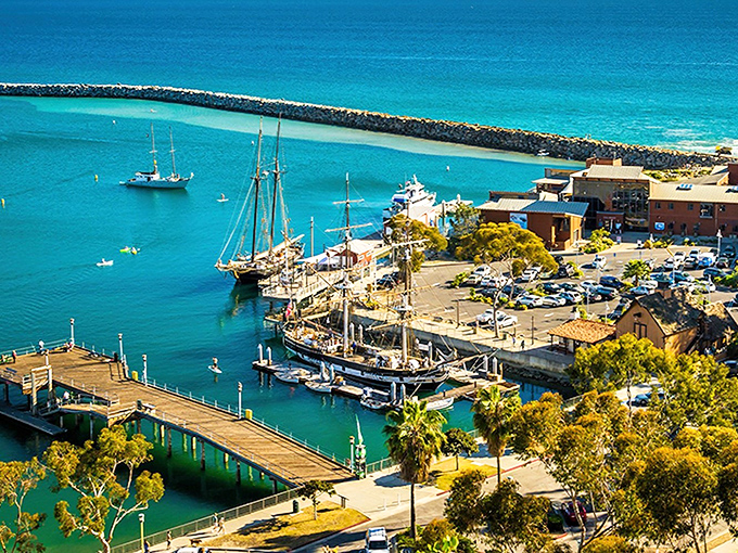 The iconic Dana Point Lantern District sign welcomes you to a slice of coastal paradise where palm trees sway and worries melt away faster than ice cream on a summer day.
