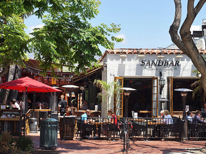 Palm trees frame the entrance to Sandbar like nature's own welcome committee, where colorful lanterns dangle like tropical fruit waiting to be picked.