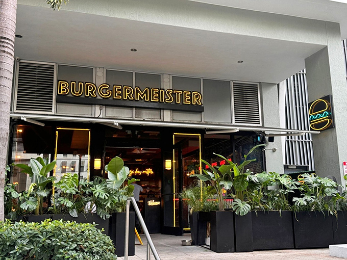 The glowing yellow Burgermeister sign beckons like a burger lighthouse in Brickell's urban jungle, promising salvation from mediocre meals.