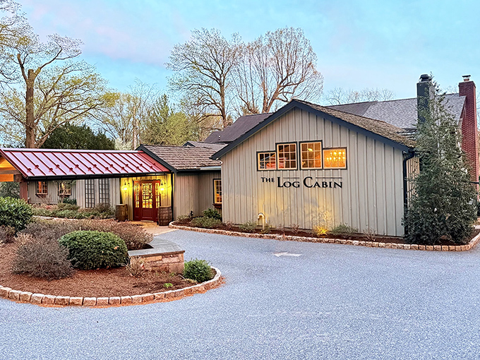 The Log Cabin's twilight glow welcomes hungry travelers with twinkling lights and rustic charm, like a culinary firefly beckoning from Amish Country.