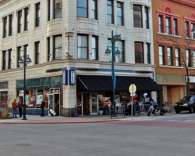 Historic charm meets modern life at this downtown Moline corner, where century-old architecture frames bustling street life beneath stylish blue awnings.