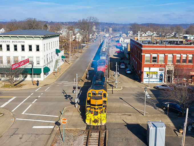 Downtown Coshocton from above, where a bright yellow train cuts through the heart of town like a cheerful messenger from another era.