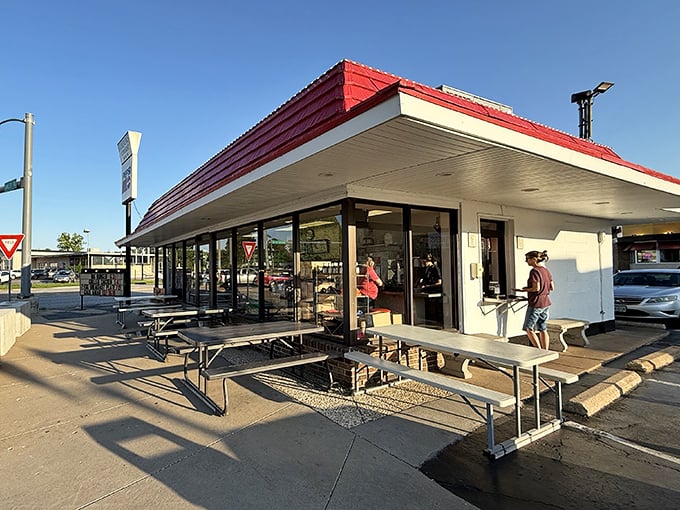 The iconic red roof of Gordon's Stop Light Drive-In stands as a beacon of burger hope along the Crystal City roadside since 1948.