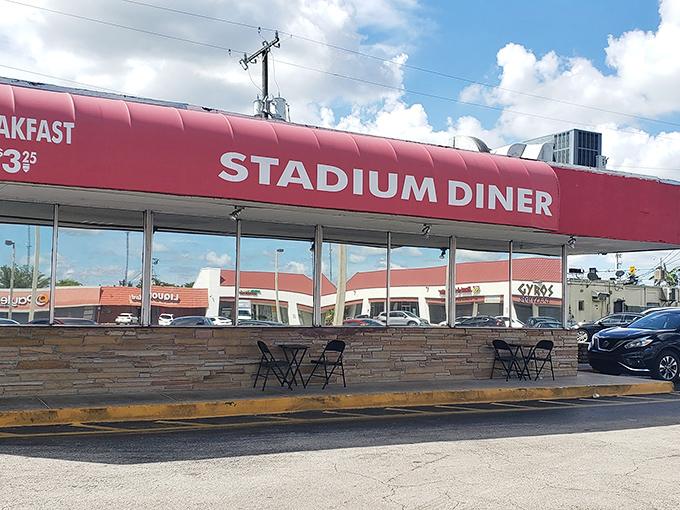The iconic red awning of Stadium Diner stands out like a culinary lighthouse, beckoning hungry travelers with promises of comfort food paradise.