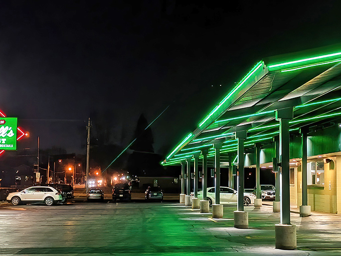 The iconic green Kroll's West sign stands proudly beside Lambeau Field, like a culinary lighthouse guiding hungry Packers fans to burger paradise.