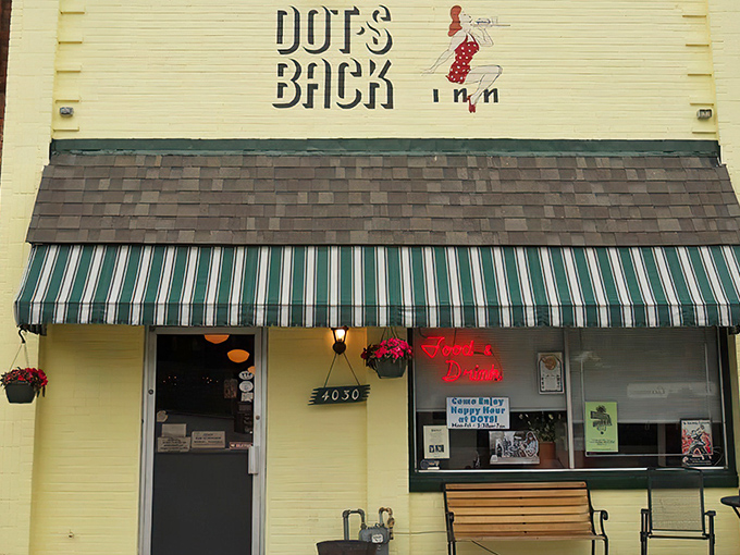 The unassuming white brick facade of Dot's Back Inn, with its vintage green striped awning, promises comfort food magic within these humble walls.