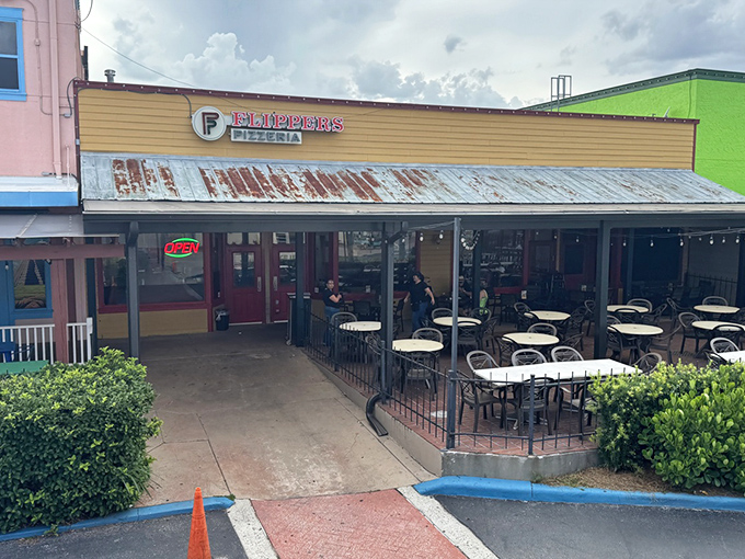 The sunshine-yellow exterior of Flippers Pizza beckons like a carb-loaded oasis in Old Town Kissimmee's colorful landscape.