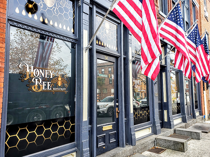 The historic brick fa&ccedil;ade of Honey Bee Restaurant stands proudly in Gettysburg, its honeycomb-patterned windows and American flags promising both comfort and patriotism inside.