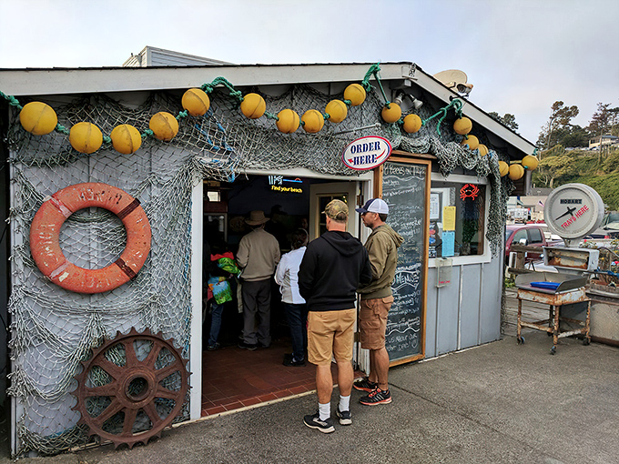 The unassuming entrance to seafood paradise. Yellow buoys dangle like maritime Christmas ornaments above this humble harbor shack where culinary magic happens daily.