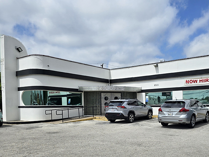 The classic white and black striped exterior of 410 Diner stands like a time capsule on Balcones Drive, promising comfort food treasures within.