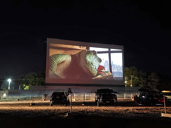 Twilight magic at its finest&mdash;cars gathered under a darkening sky as comedy and tragedy masks illuminate the massive screen at Skyview Drive-In.