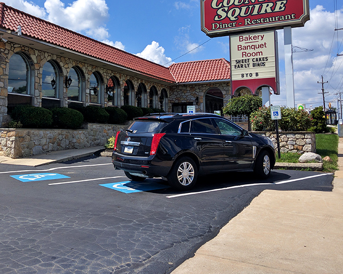 The neon glow of Country Squire Diner's sign against twilight skies promises comfort food salvation after a long day. Stone walls and warm lighting beckon hungry travelers inside.