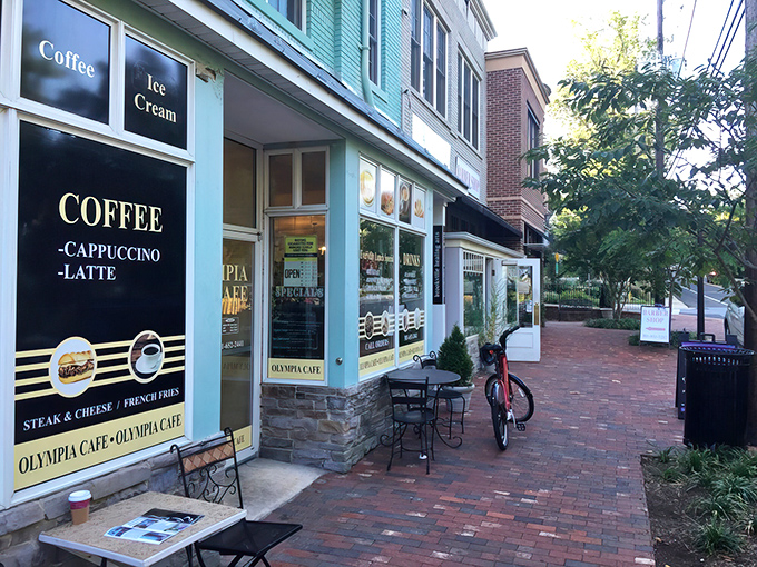 The mint-green facade of Olympia Cafe stands like a time capsule on Chevy Chase's brick-lined street, promising comfort food treasures within.